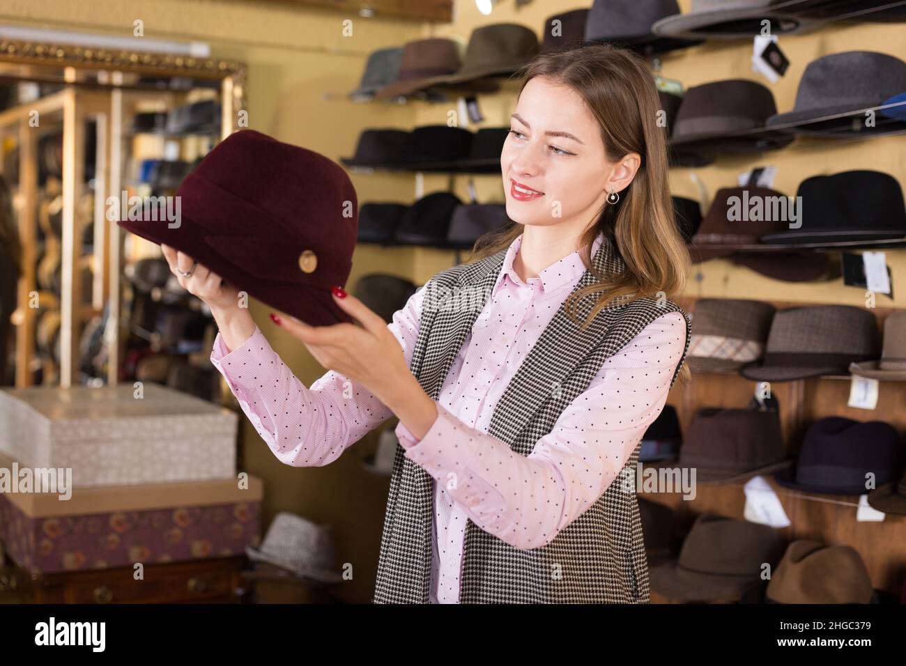 Woman choosing hat in store Stock Photo - Alamy