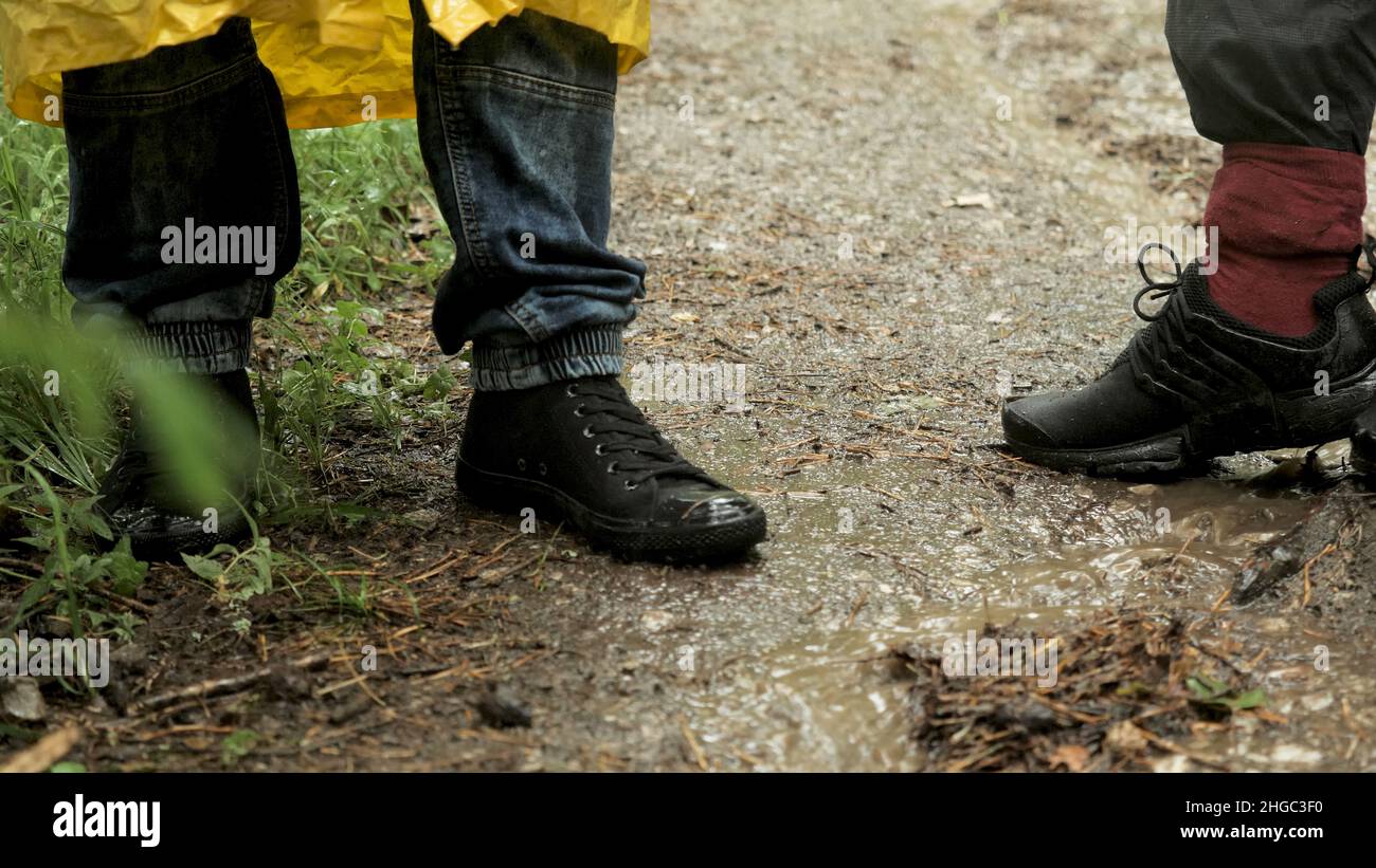 People trekking in the forest under the rain. Close up of male legs ...