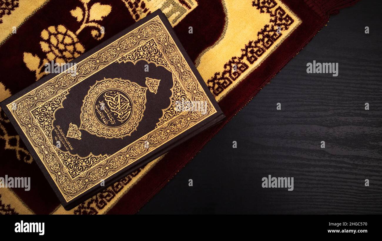 A Holy Quran on a Prayer Rug Background Stock Photo - Alamy