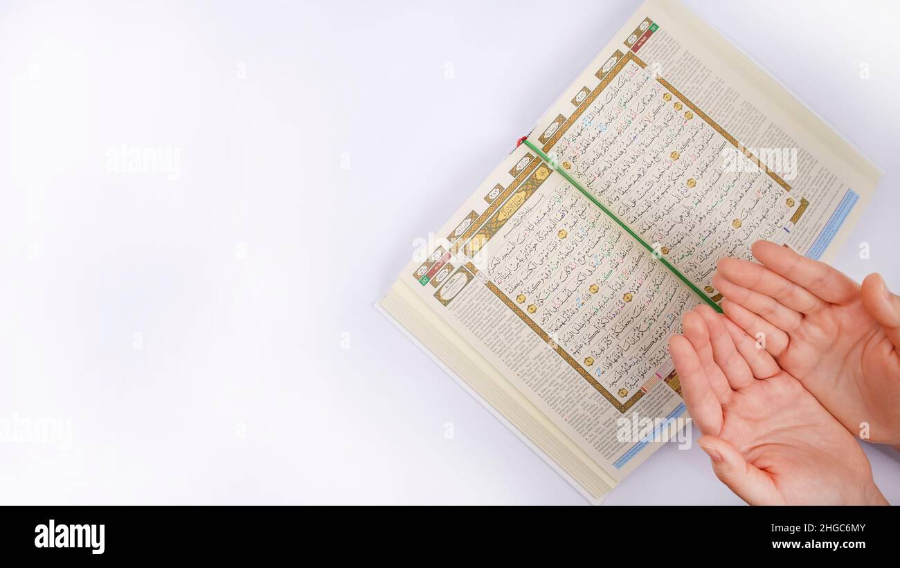Hands Making Dua In Front of an Open Holy Quran Stock Photo - Alamy