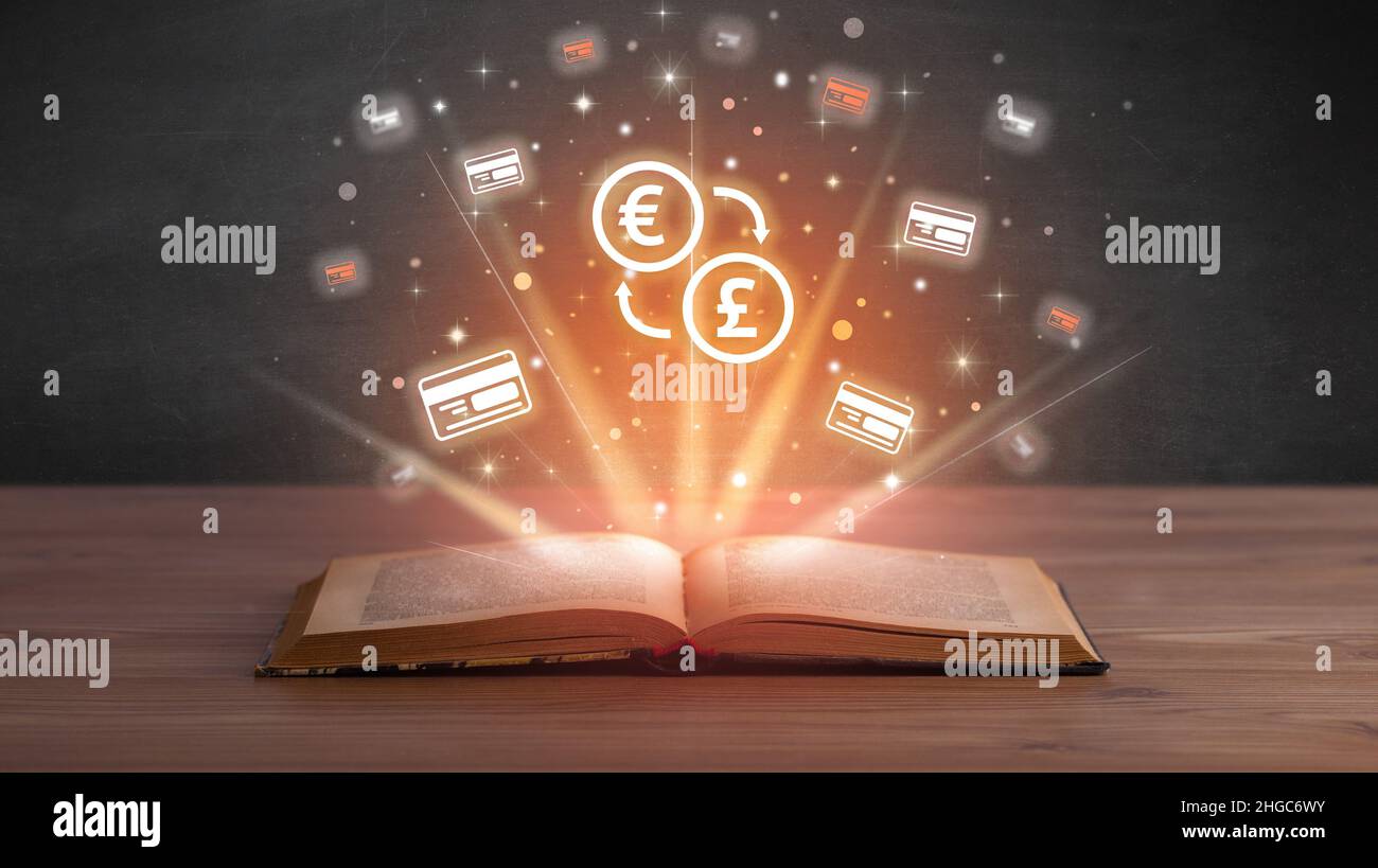 Open book with currency icons above Stock Photo - Alamy