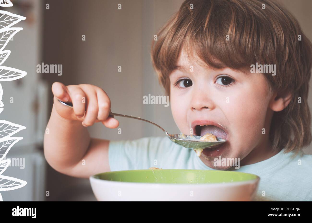 Hungry little boy eating. Cheerful baby child eats food itself with ...