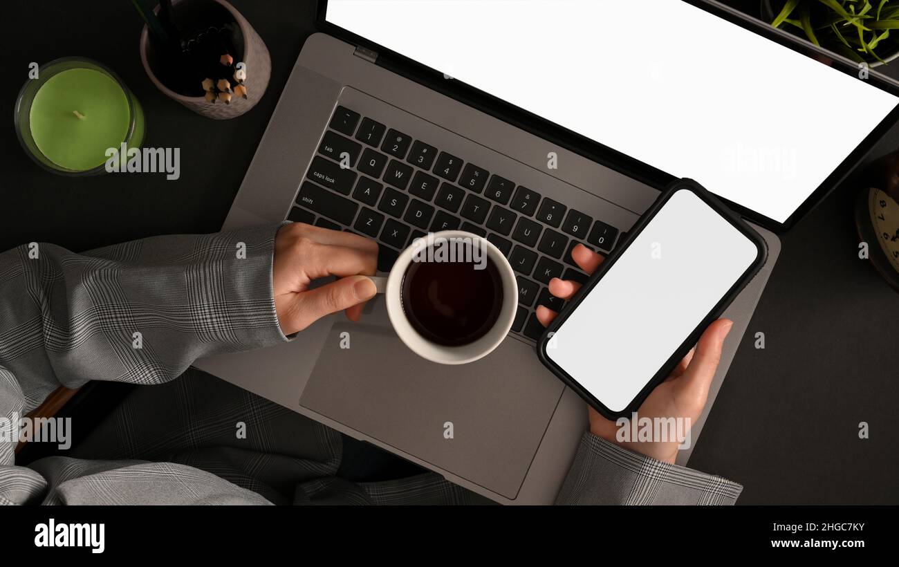 Top view of a businesswoman using her smartphone while sipping morning ...
