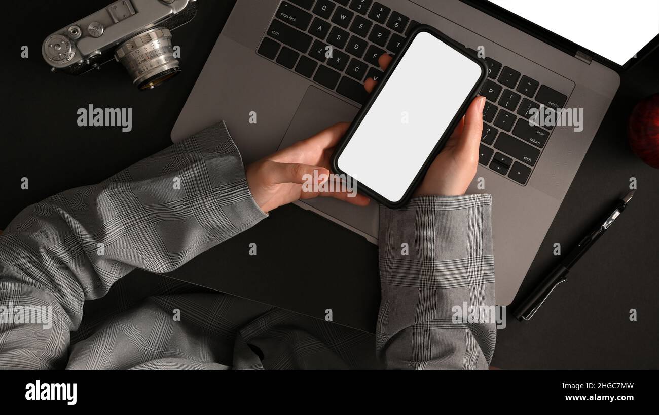 Overhead shot of a businesswoman texting on her smartphone during ...