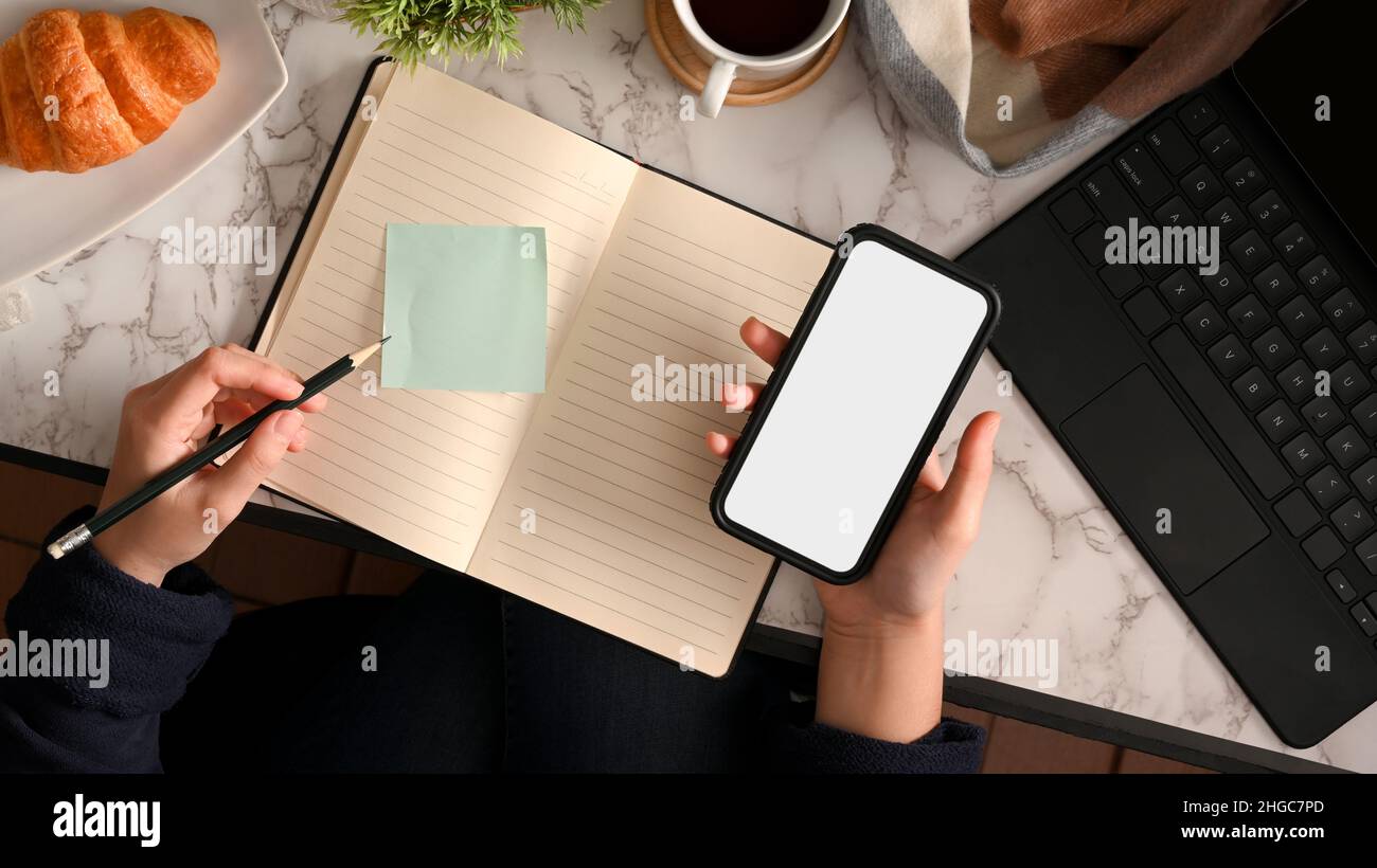 Top view, A female university student taking a notes on sticky note ...