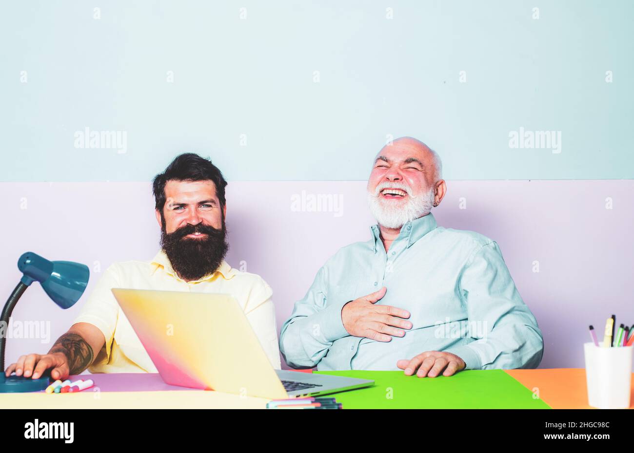 Couple Of Two Young Office Workers Laugh Looking At Laptop Screen