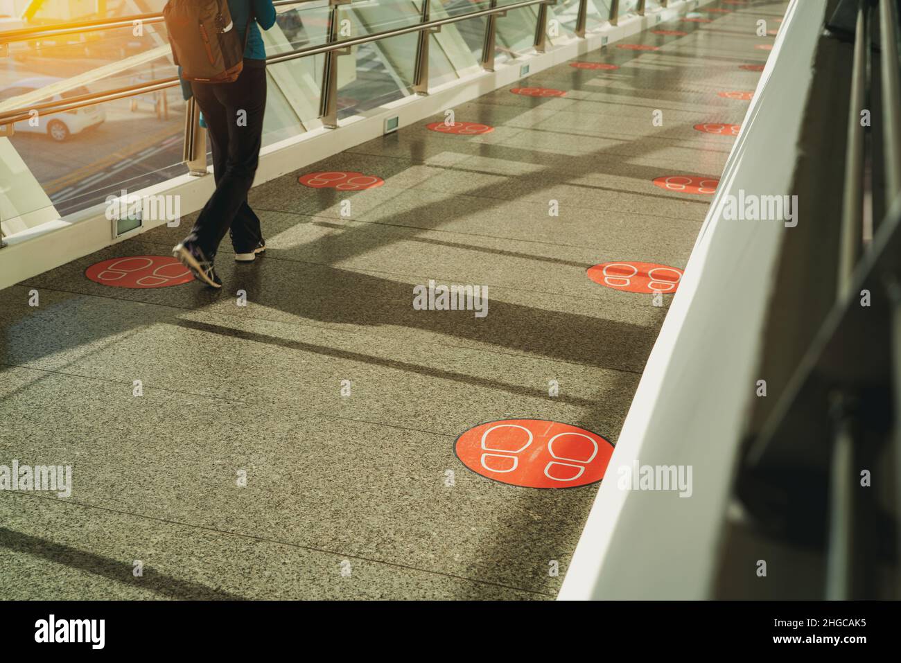 Back view of woman walking on pedestrian glass bridge. Corridor ...