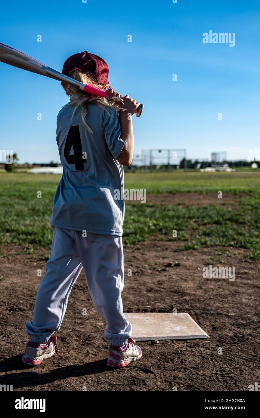 Young girl with ponytail practicing swinging a baseball bat Stock Photo ...