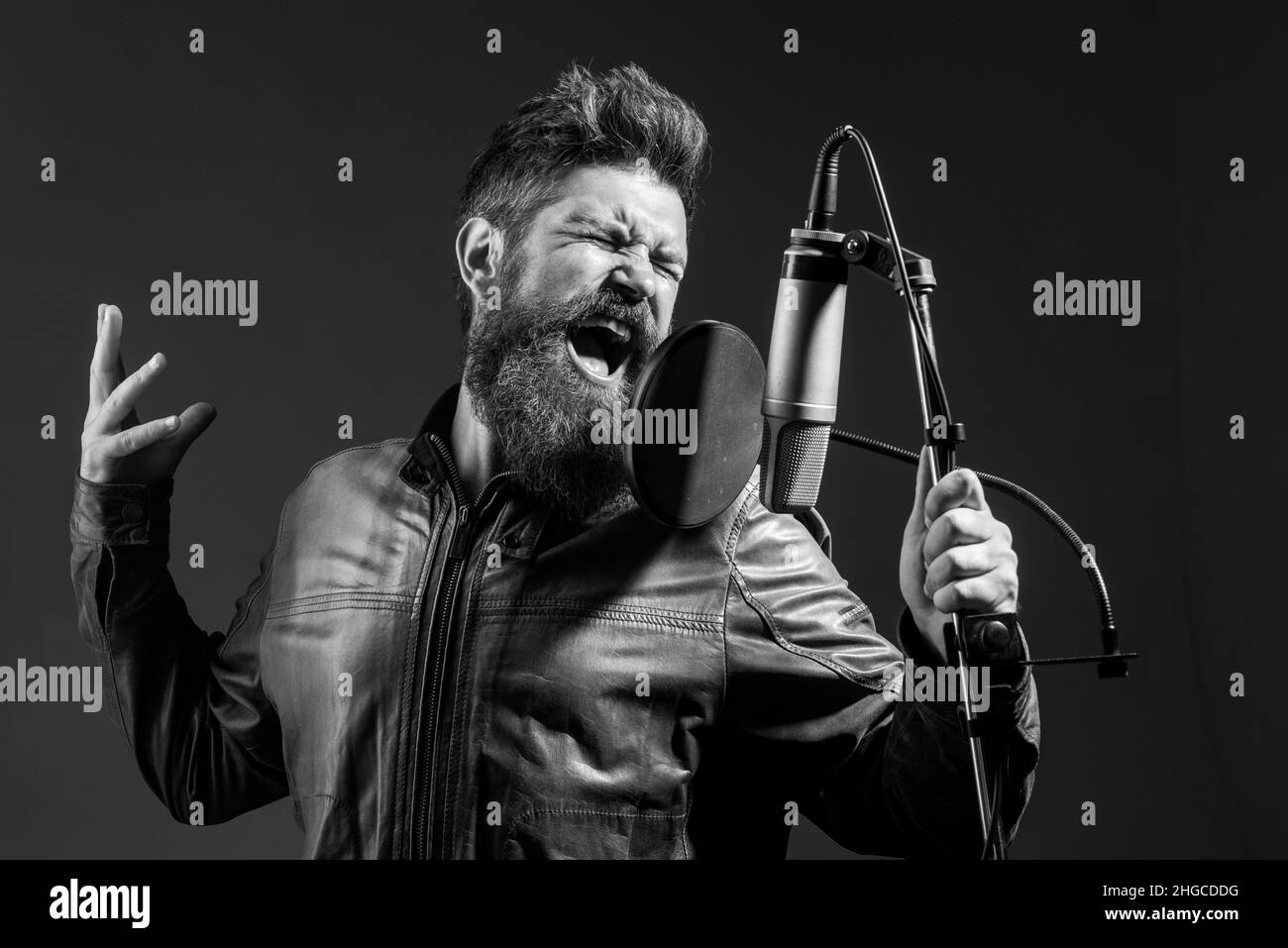 Singing man in a recording studio. Expressive bearded man with ...