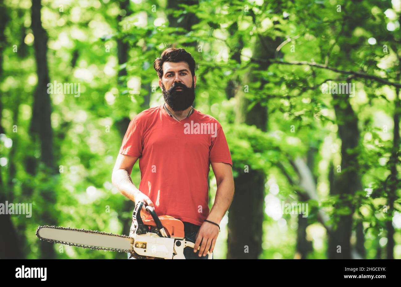 Handsome young man with axe near forest. Lumberjack concept ...