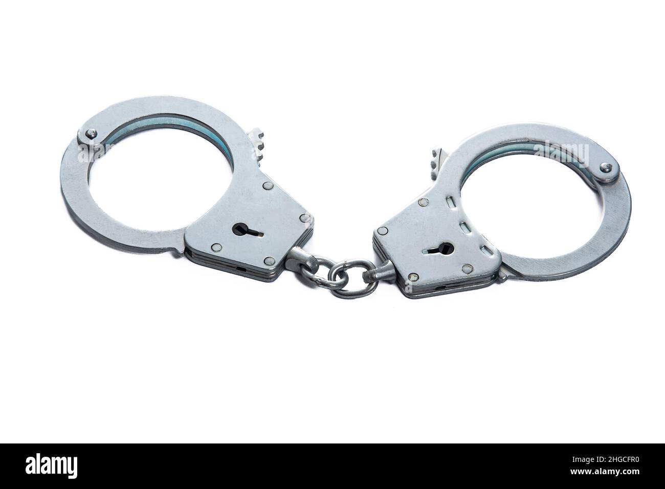 Metal handcuffs on a white isolated background Stock Photo - Alamy