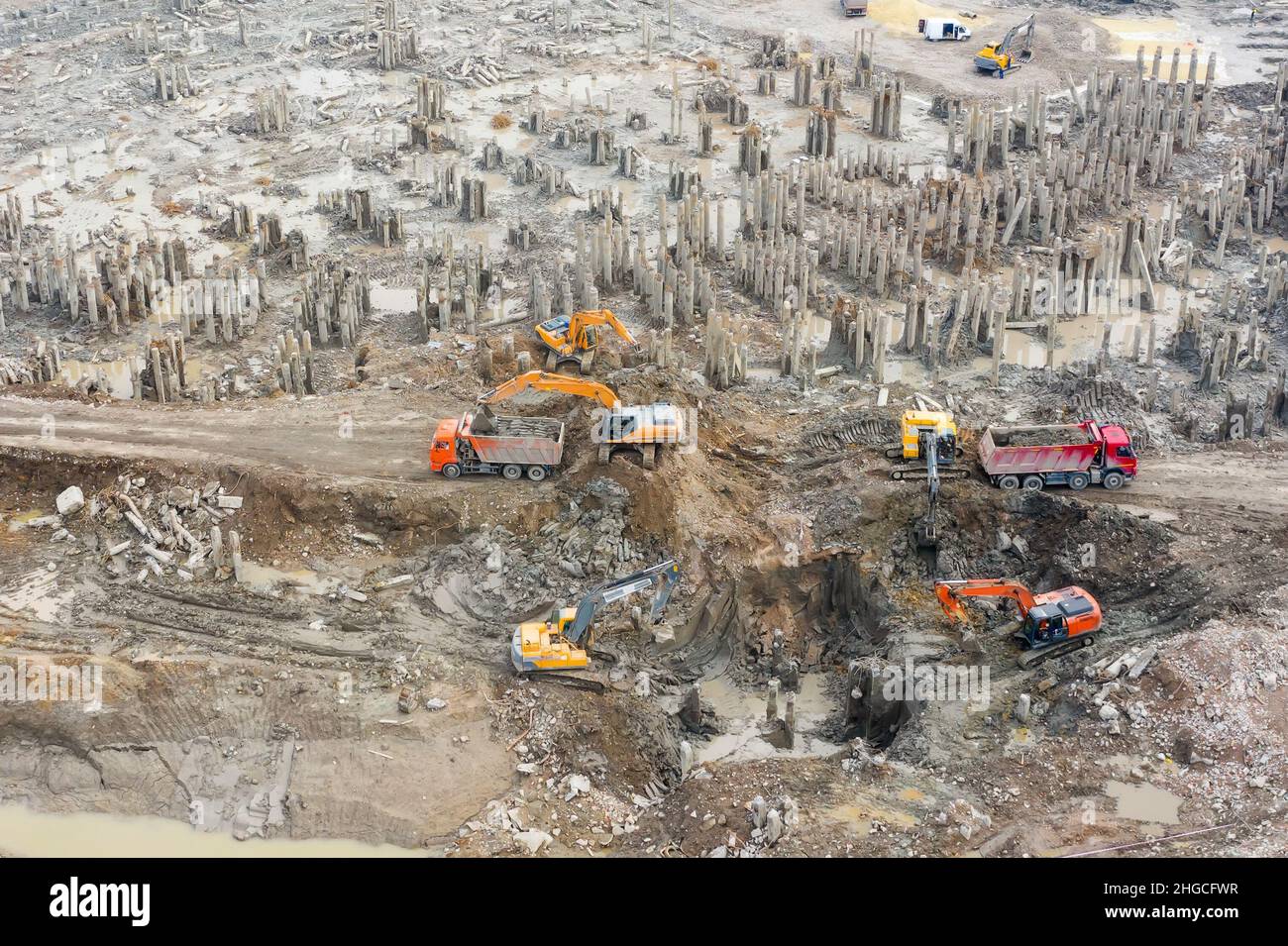 Aerial view of the pit with piles of the building, demolition. Trucks ...