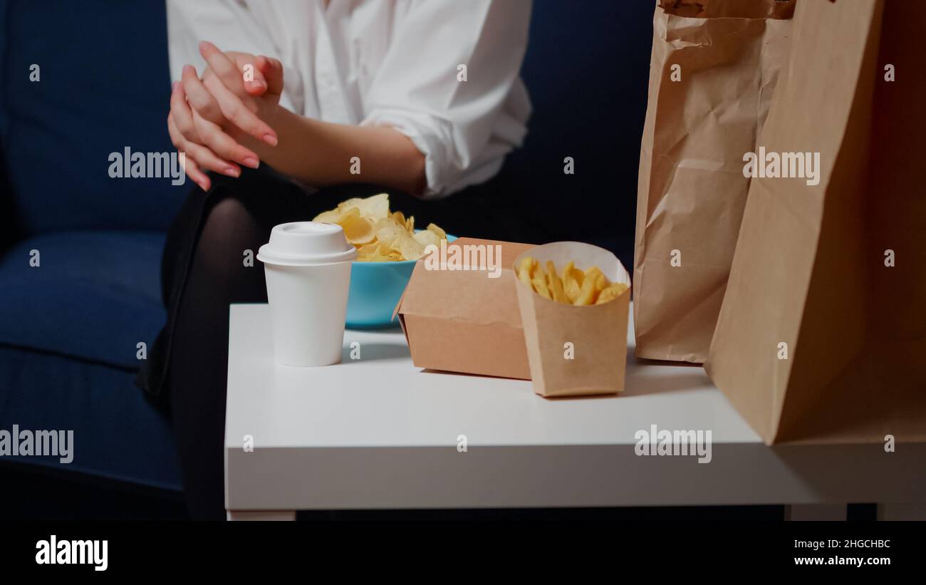 Close up of white table with fast food takeaway meal and woman sitting ...