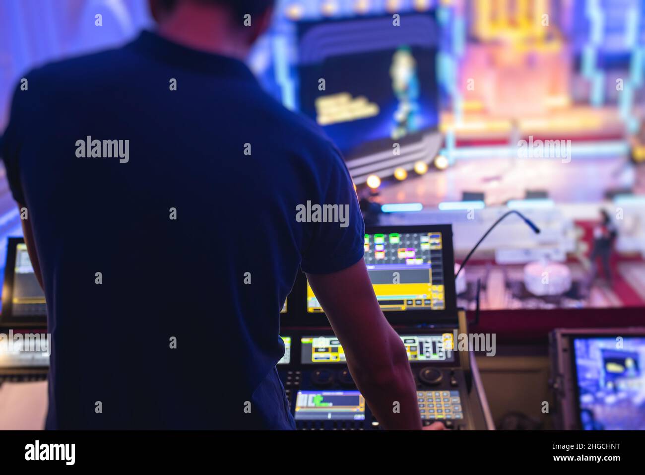 View of lighting technician operator working on mixing console ...
