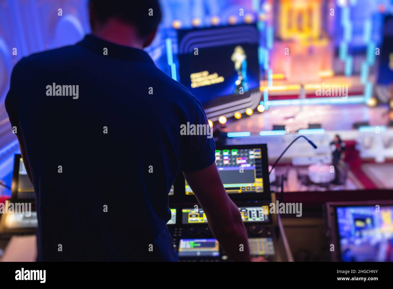 View of lighting technician operator working on mixing console ...