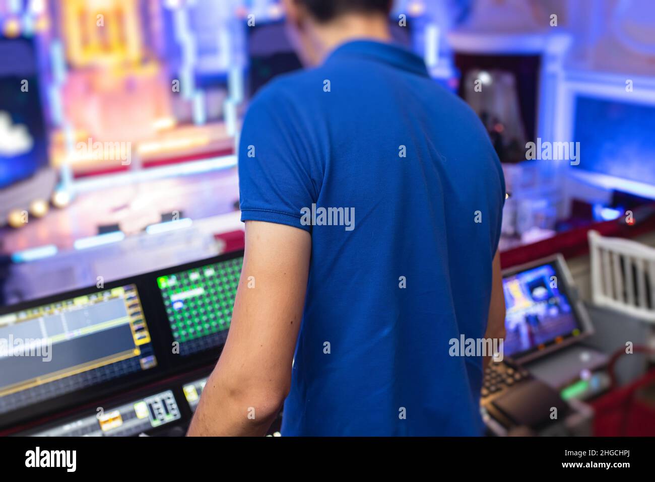View of lighting technician operator working on mixing console ...