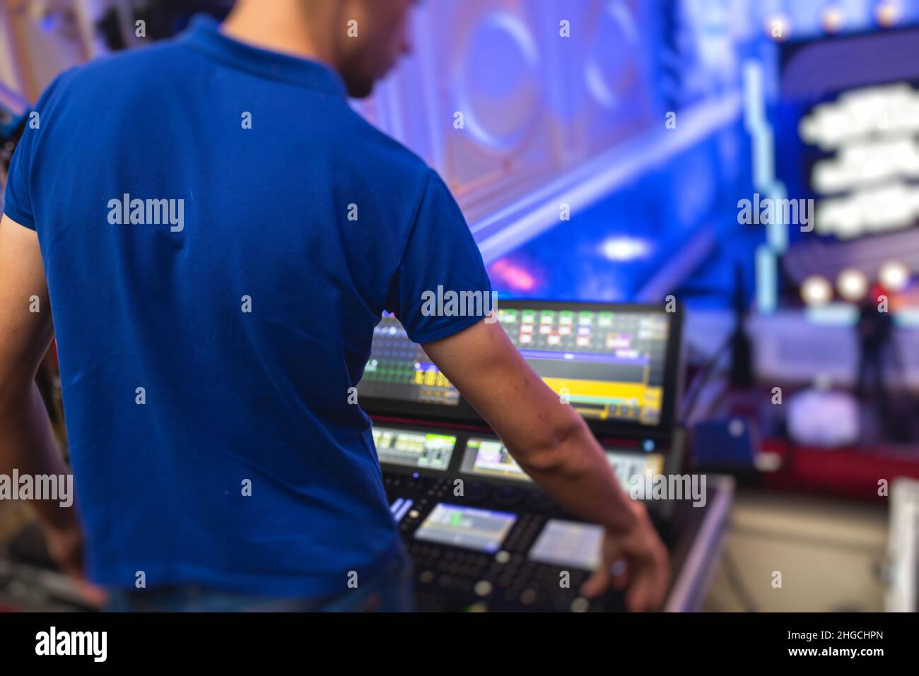 View of lighting technician operator working on mixing console ...