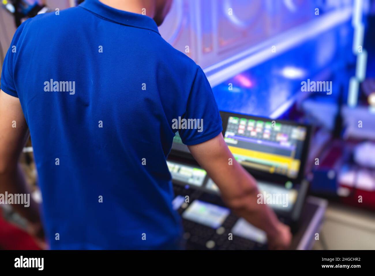 View of lighting technician operator working on mixing console ...