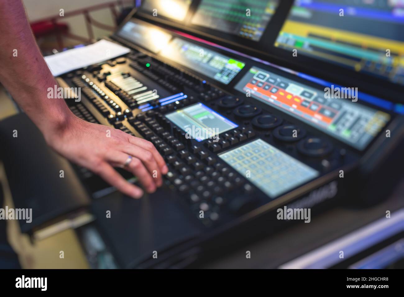 View of lighting technician operator working on mixing console ...