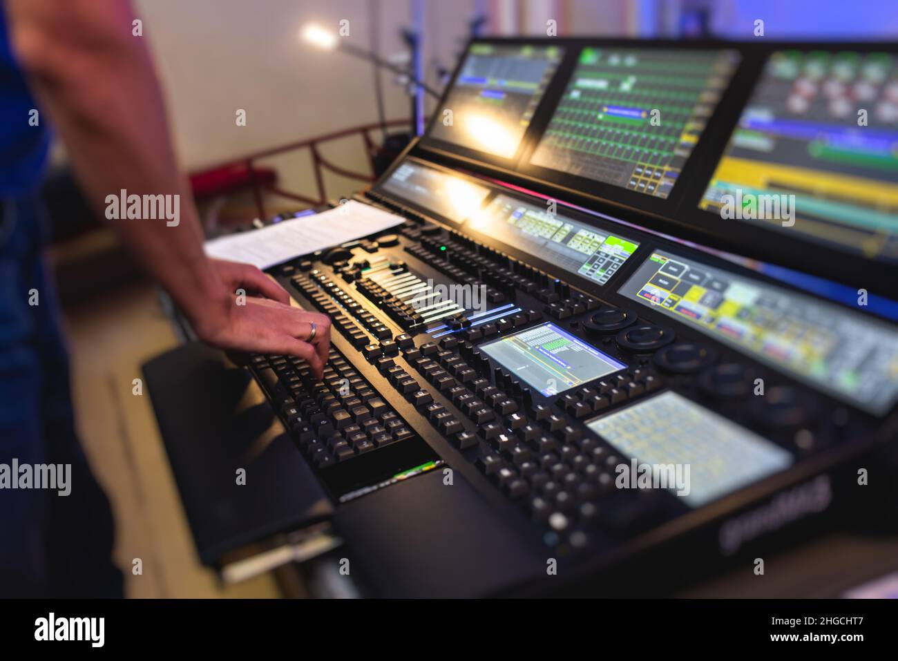 View of lighting technician operator working on mixing console ...