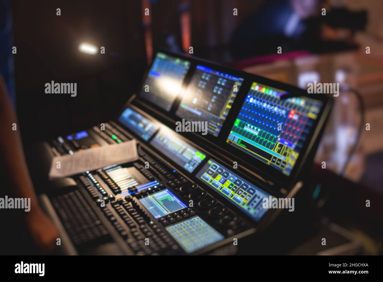 View of lighting technician operator working on mixing console ...