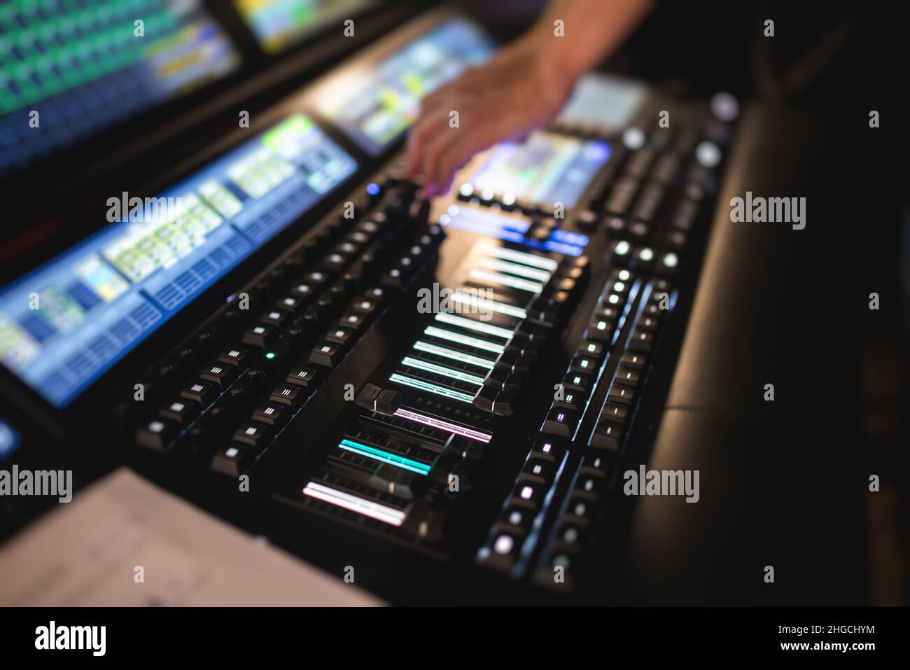 View of lighting technician operator working on mixing console ...