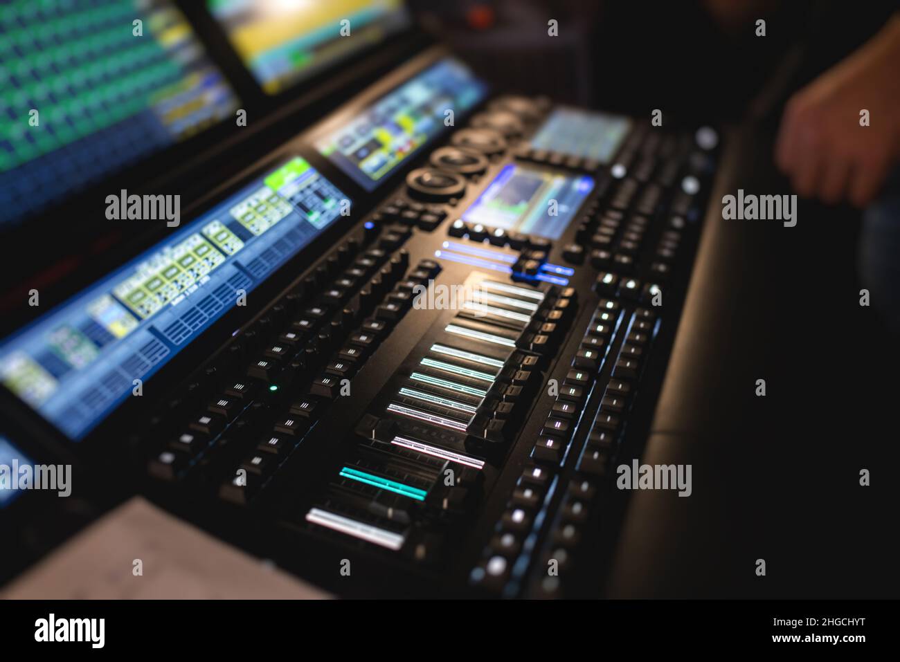 View of lighting technician operator working on mixing console ...