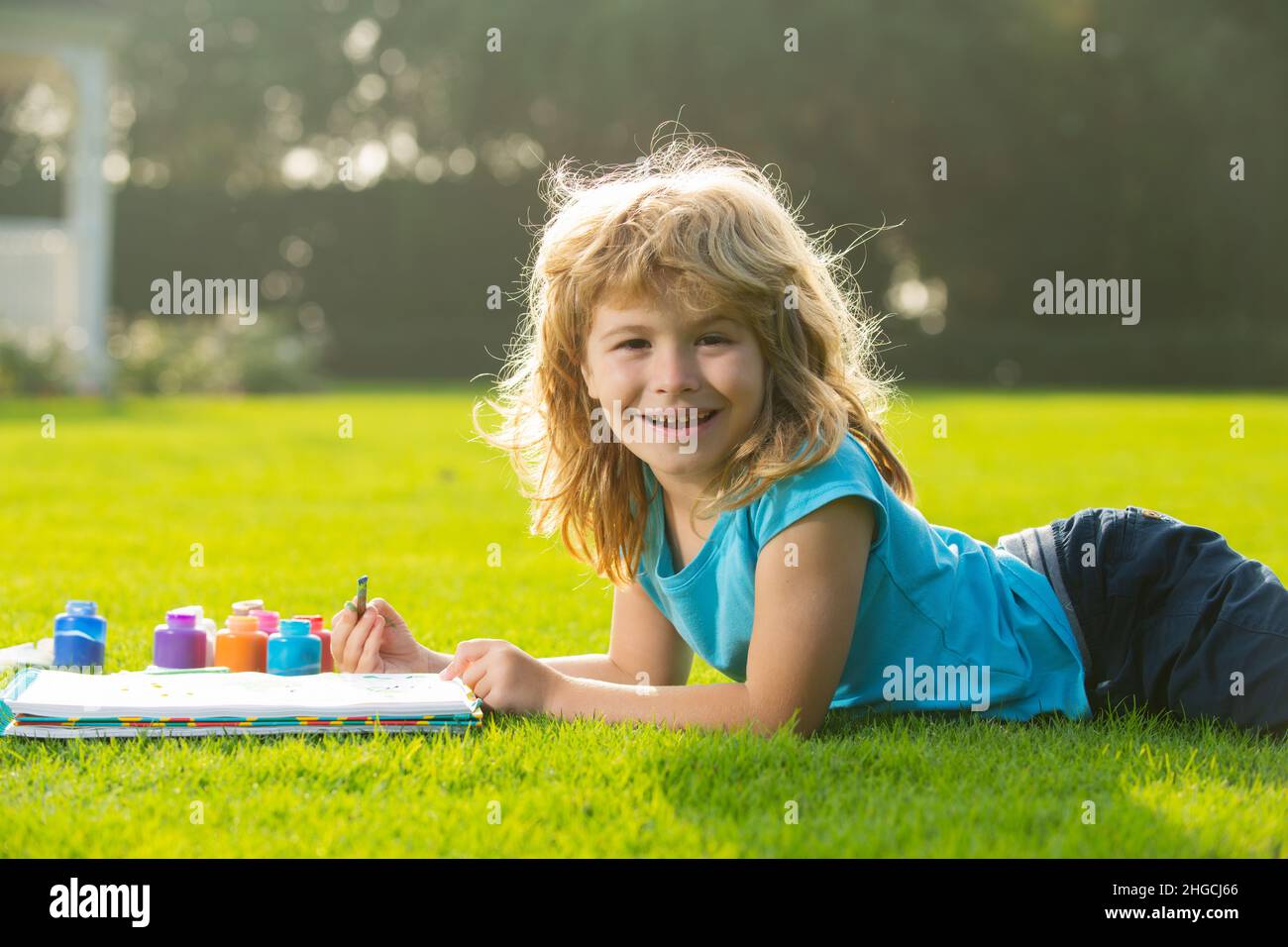 Young talented boy artist painter. Child boy draws in park laying in ...