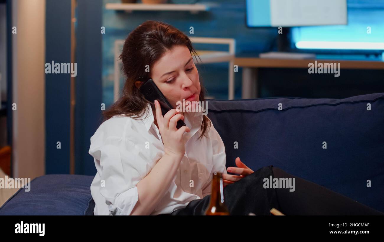 Annoyed woman answering smartphone call while eating chinese takeaway ...