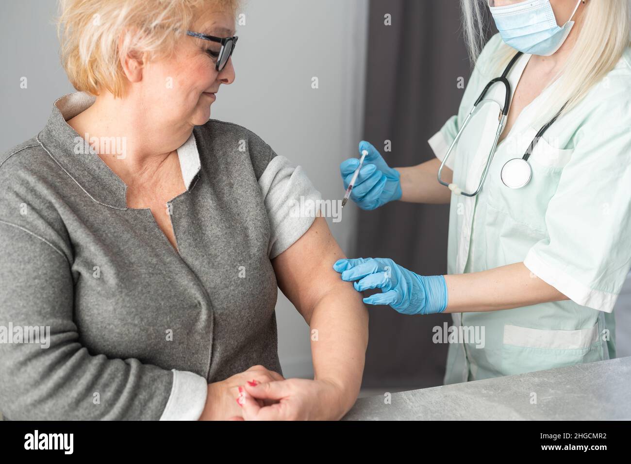 Closeup nurse doing vaccine injection to senior woman Stock Photo - Alamy