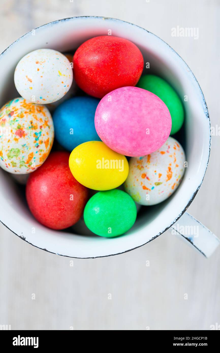 Easter candy eggs on white wooden surface Stock Photo - Alamy