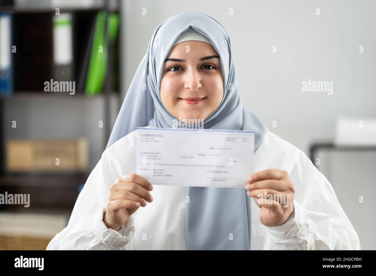 Happy Muslim Woman Holding Bank Cheque Or Paycheck Stock Photo - Alamy