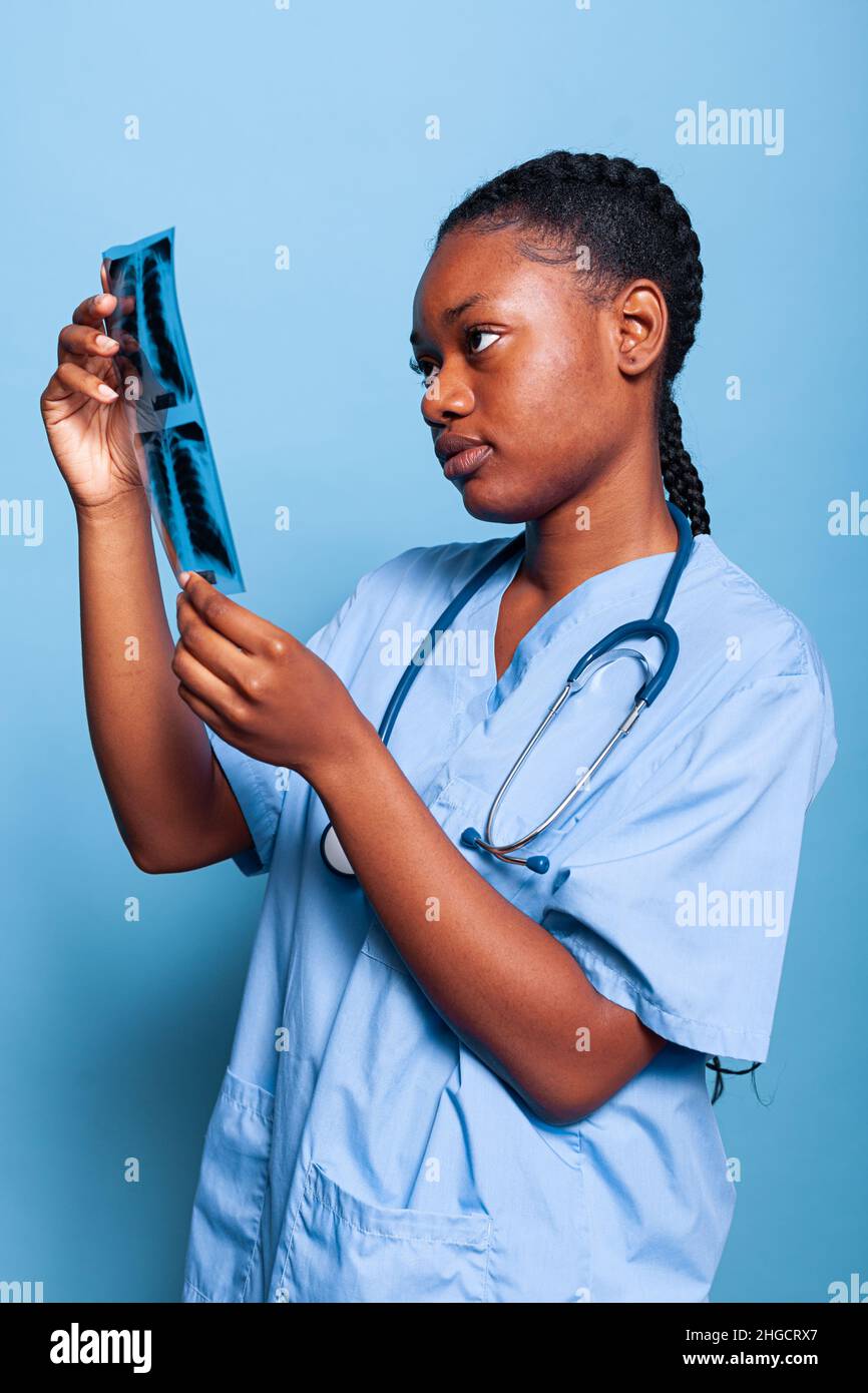 African american practitioner nurse holding radiography analyzing lungs ...