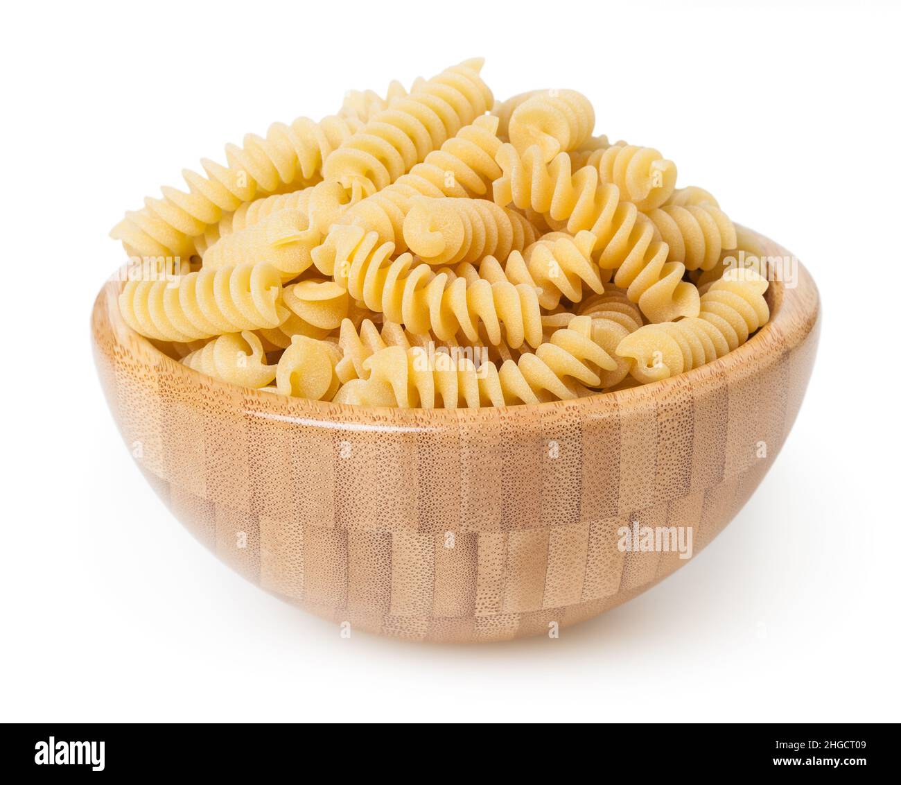 Uncooked fusilli pasta in wooden bowl isolated on white background with ...