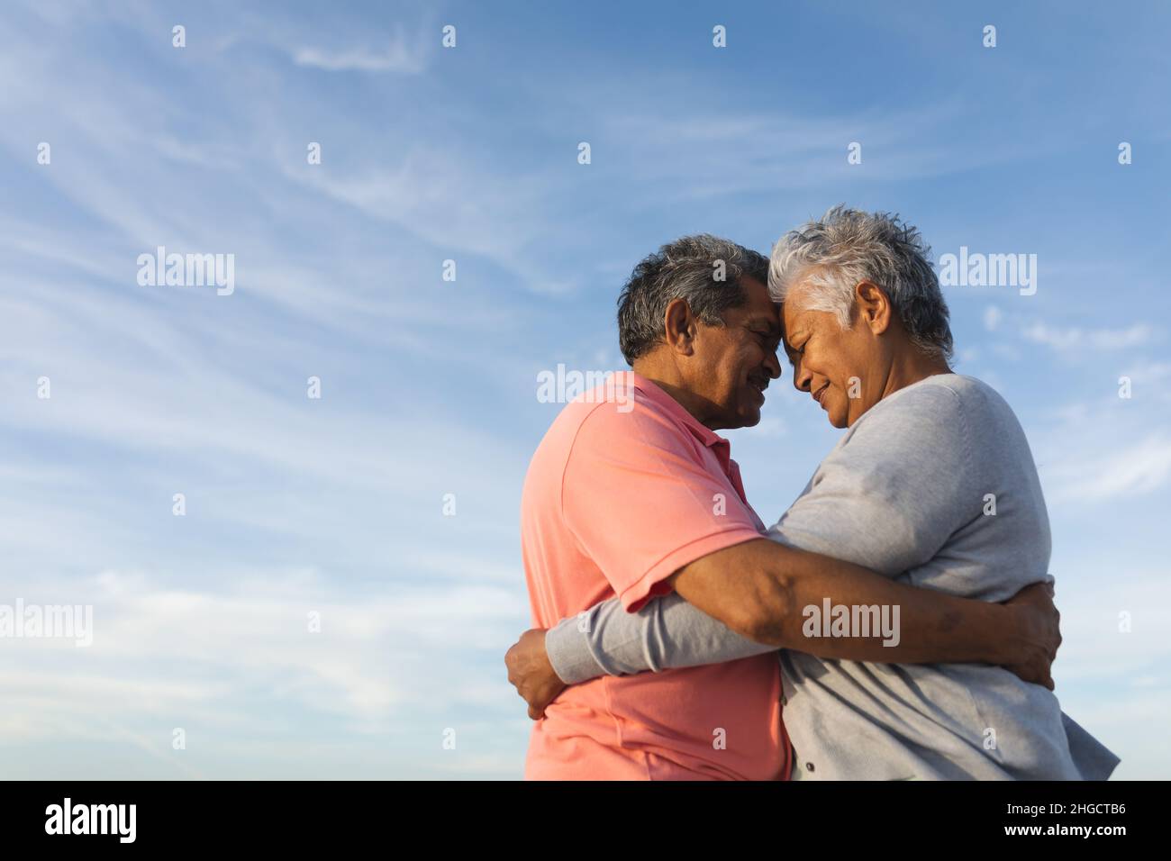 Side view of affectionate multiracial senior couple embracing while ...