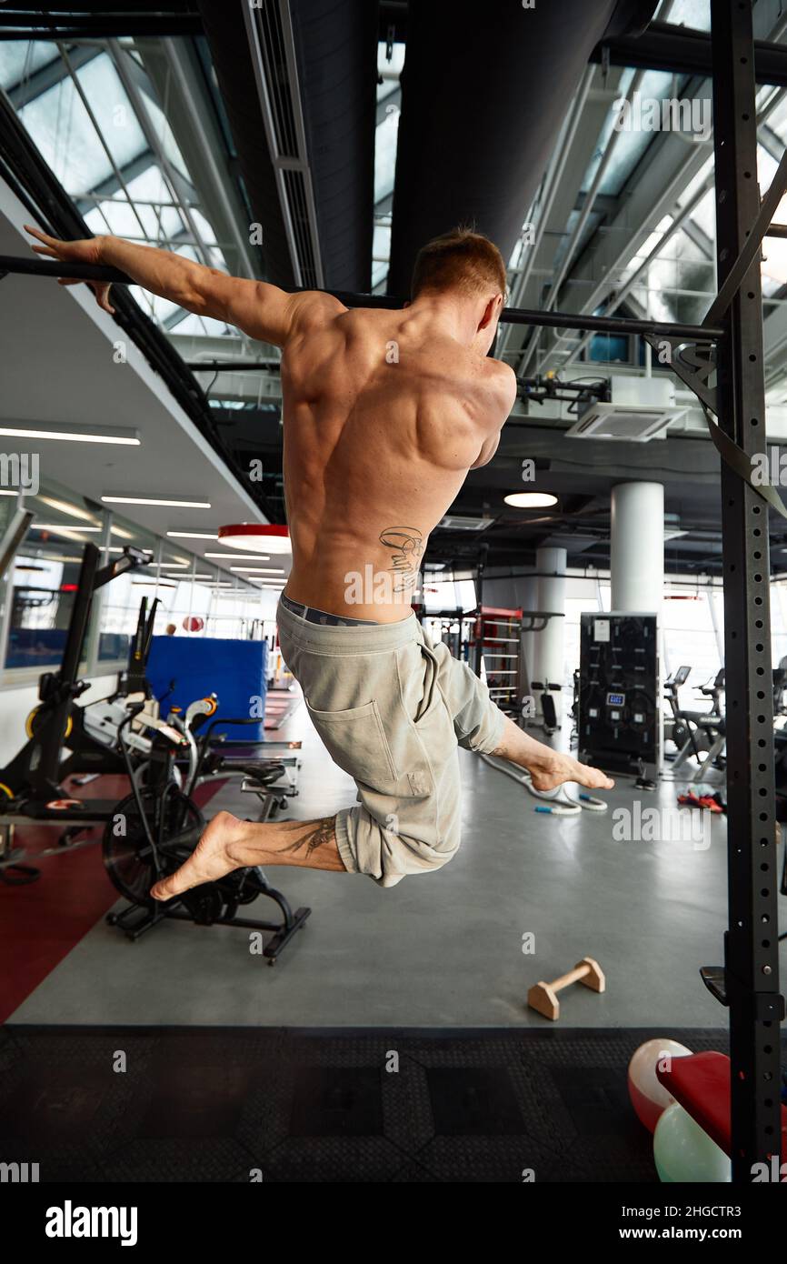 Muscular strong man exercising in the sport gym, Man doing horizontal ...