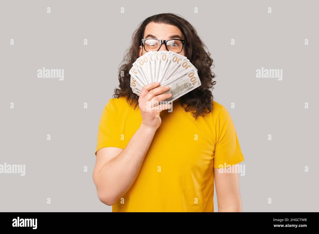 Photo of young excited young man holding money over face Stock Photo ...