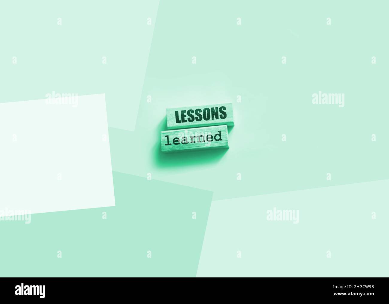 Wooden blocks wtih text Lessons learned on pink background. Business ...