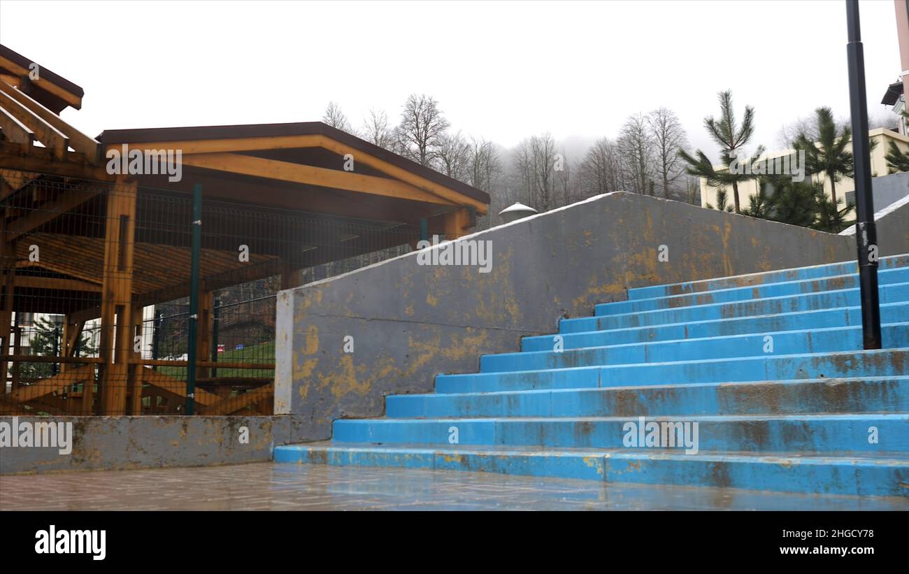Wooden pavilion in raining season located near concrete stairs on grey ...