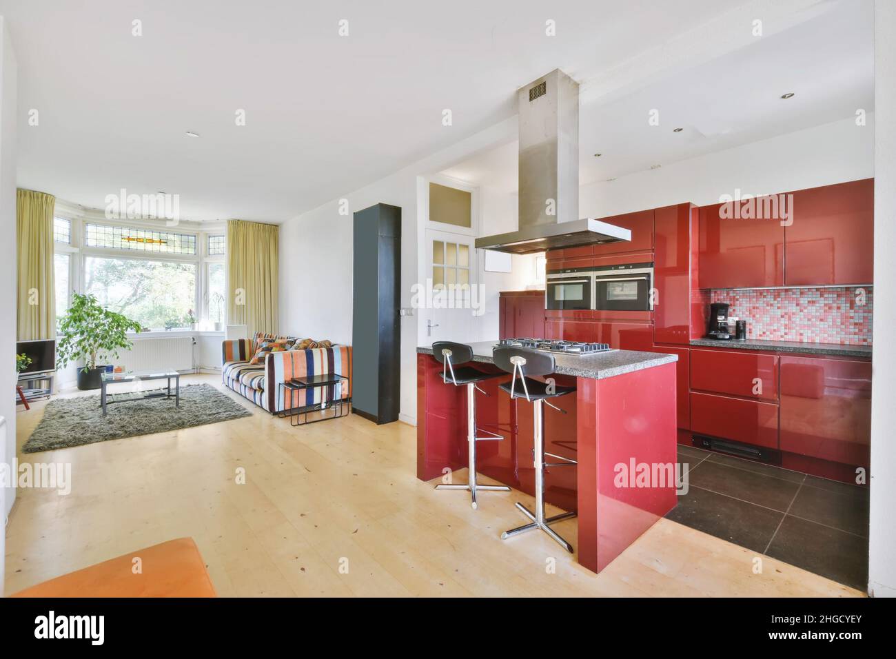 Attractive kitchen with a red kitchen set and windows Stock Photo - Alamy