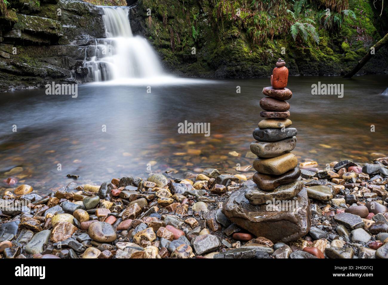 Stone stacking or rock balancing at waterfall. Zen balanced pebbles ...