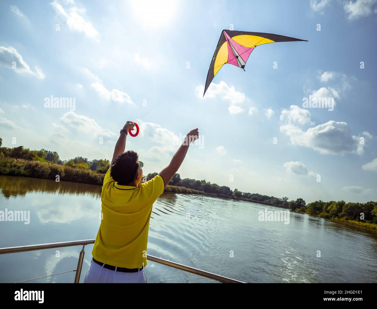 young man is standing on terrace of floating house and starting to fly ...