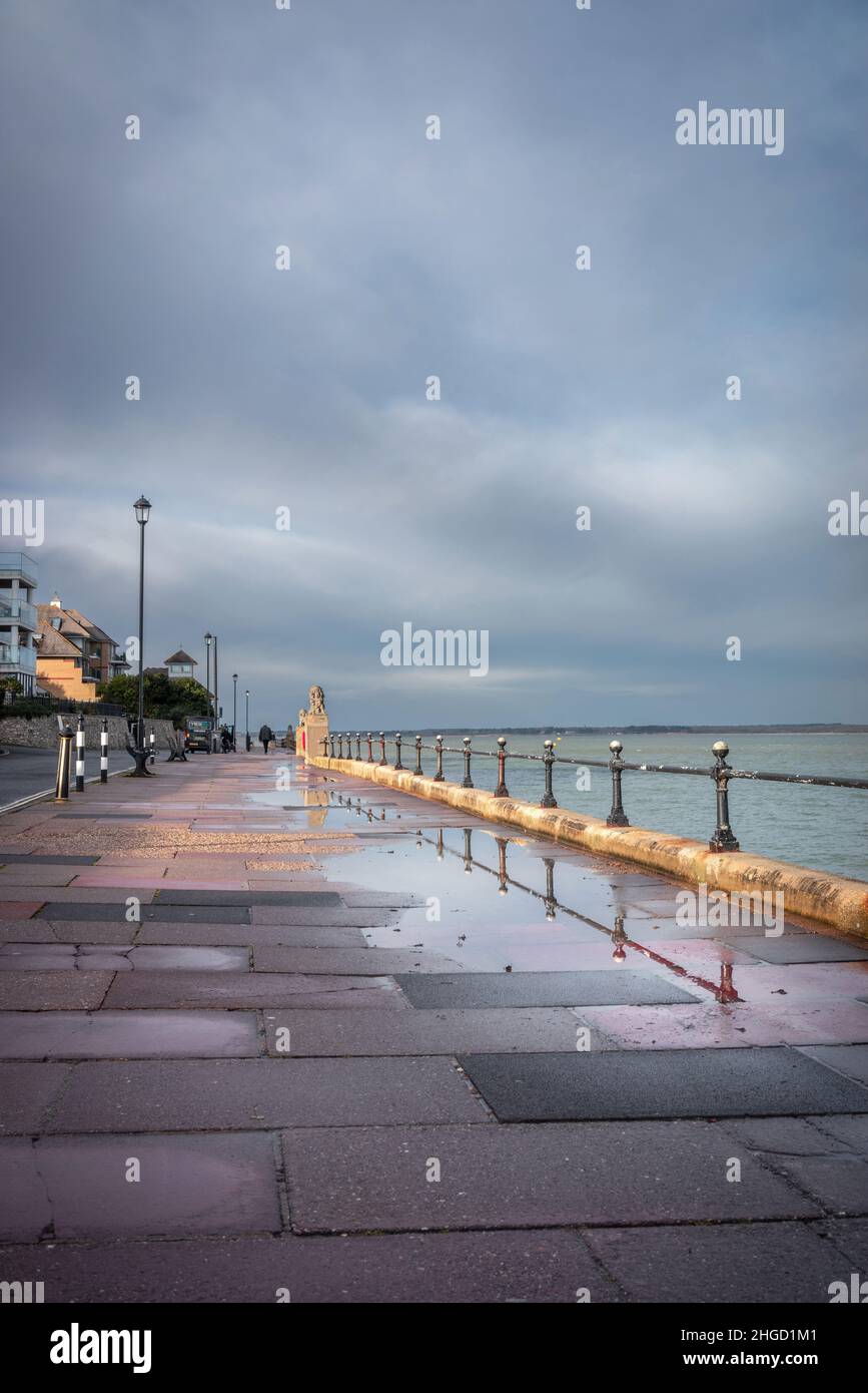 Cowes seafront promenade reflection in a puddle after rain, Cowes, Isle ...