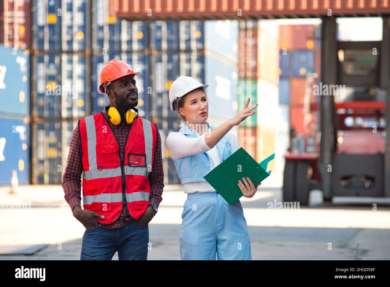 Businesswoman and engineer talking and checking loading Containers box ...