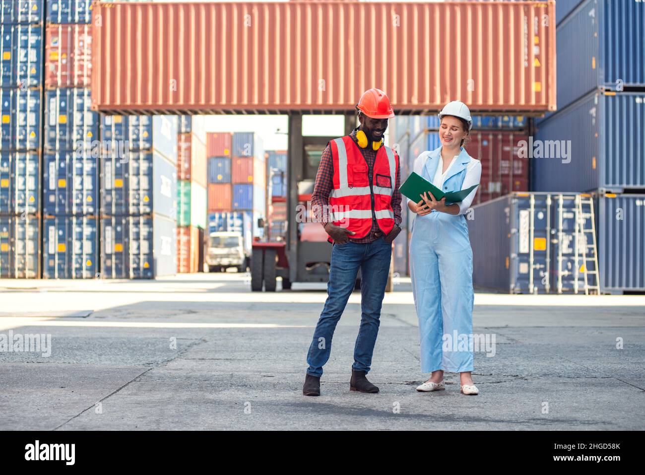 Businesswoman and engineer talking and checking loading Containers box ...