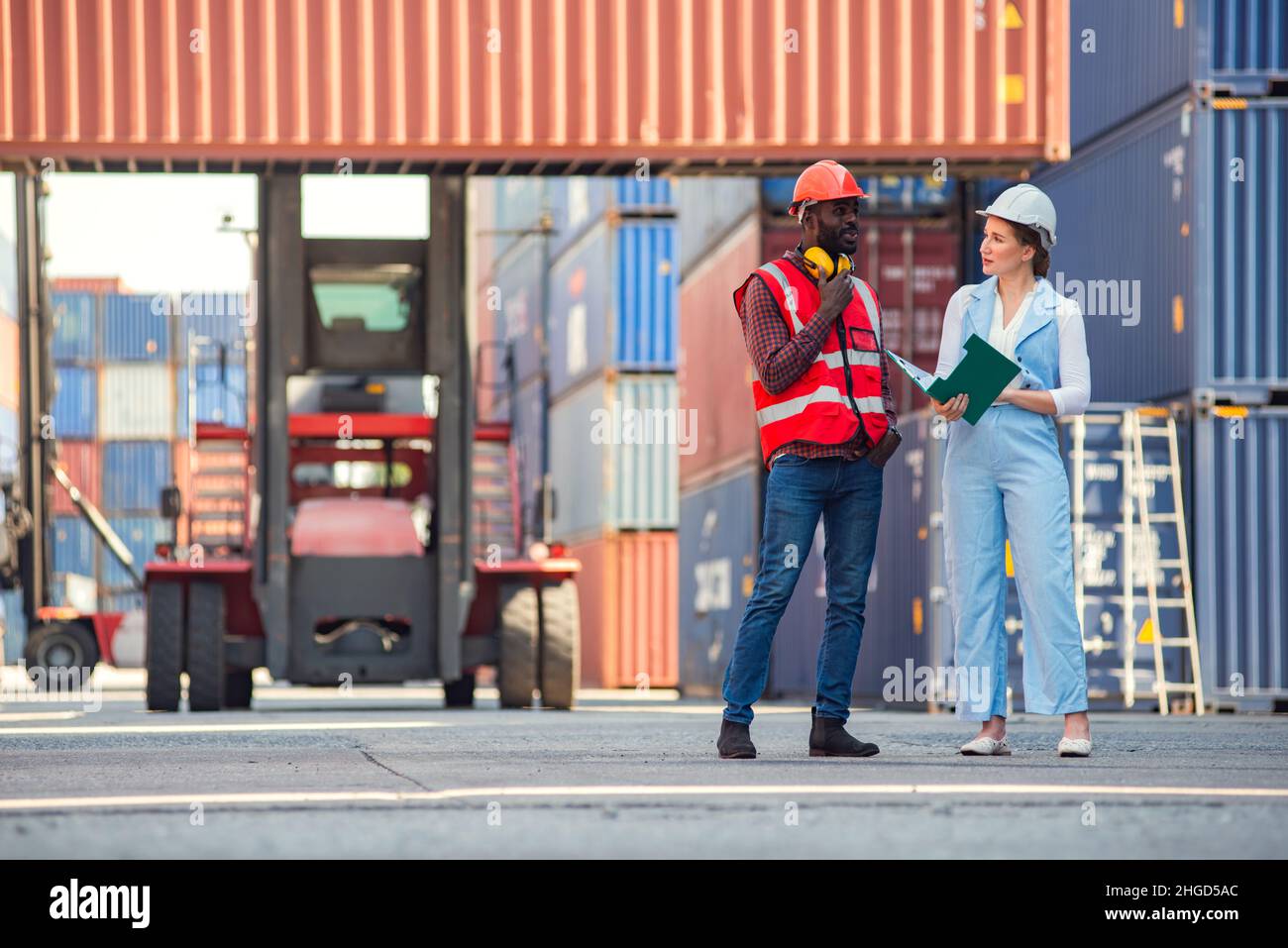 Businesswoman and engineer talking and checking loading Containers box ...