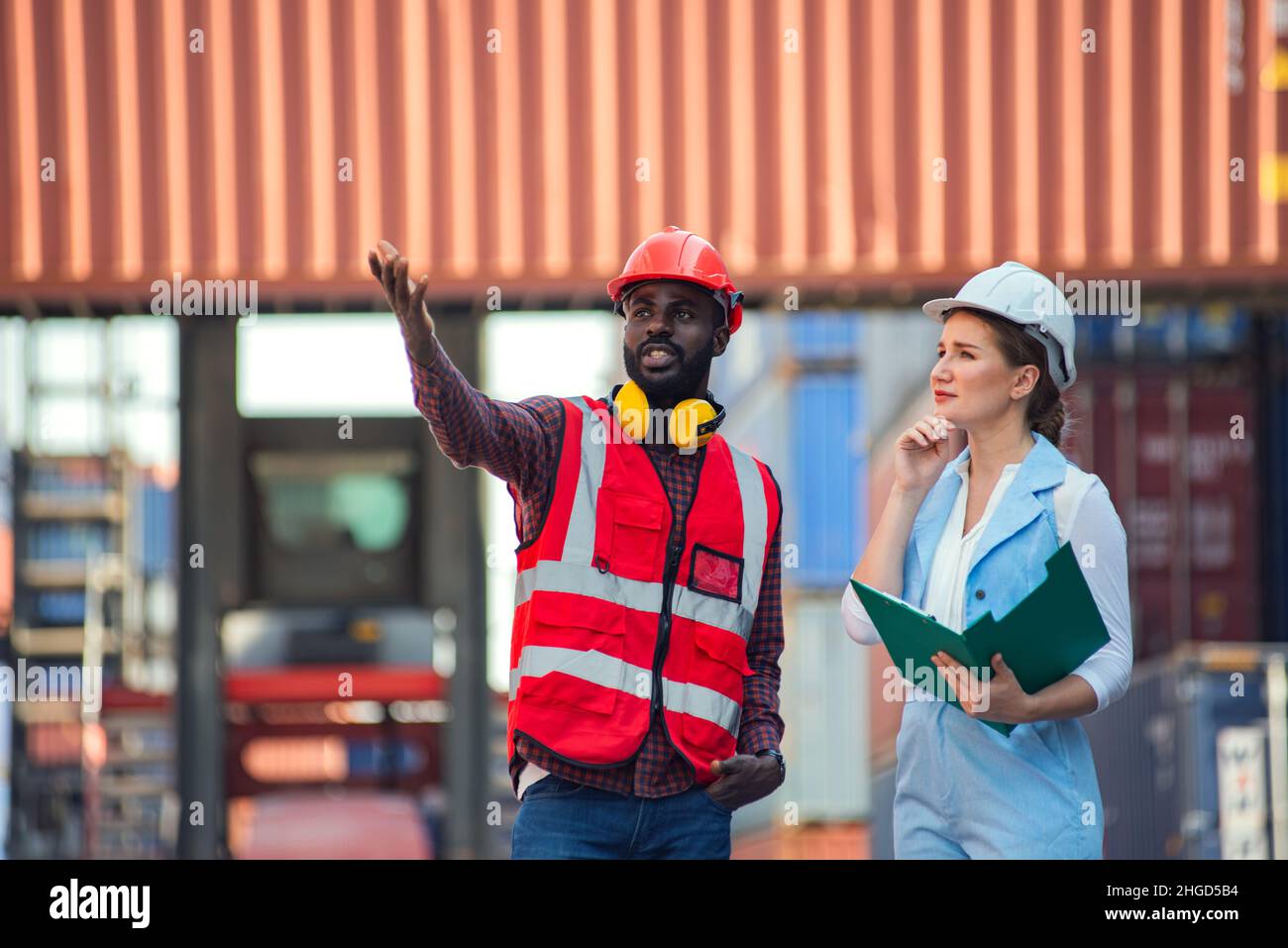 Businesswoman and engineer talking and checking loading Containers box ...