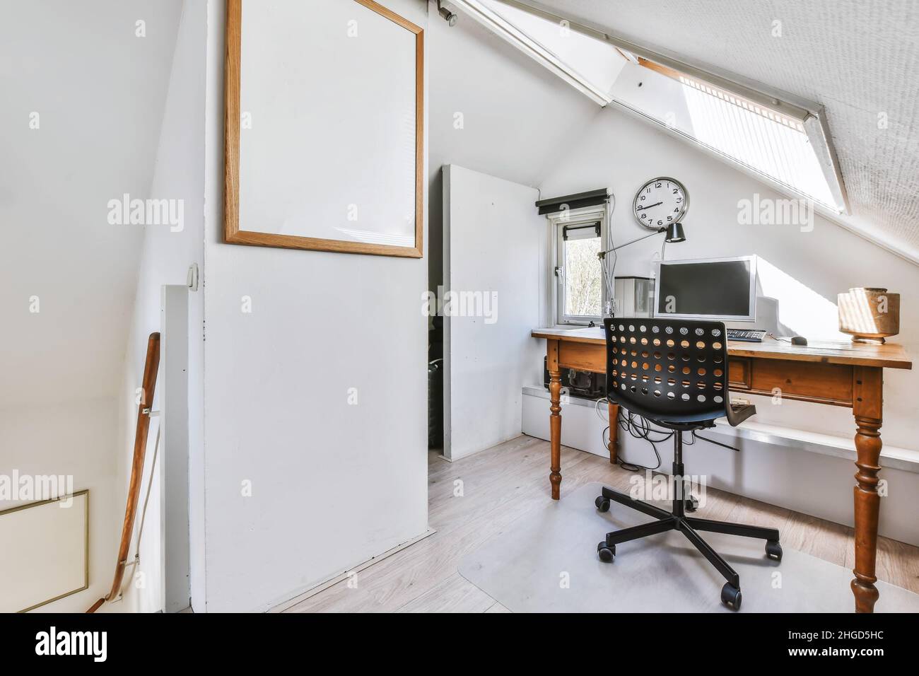 Stunning attic for a work room with a wooden table and a computer Stock ...