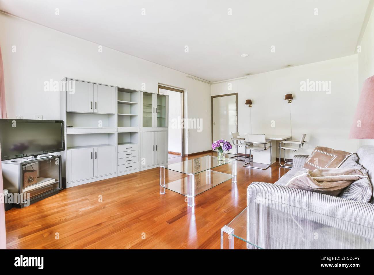 A beautiful living area with a glass coffee table and a light sofa ...