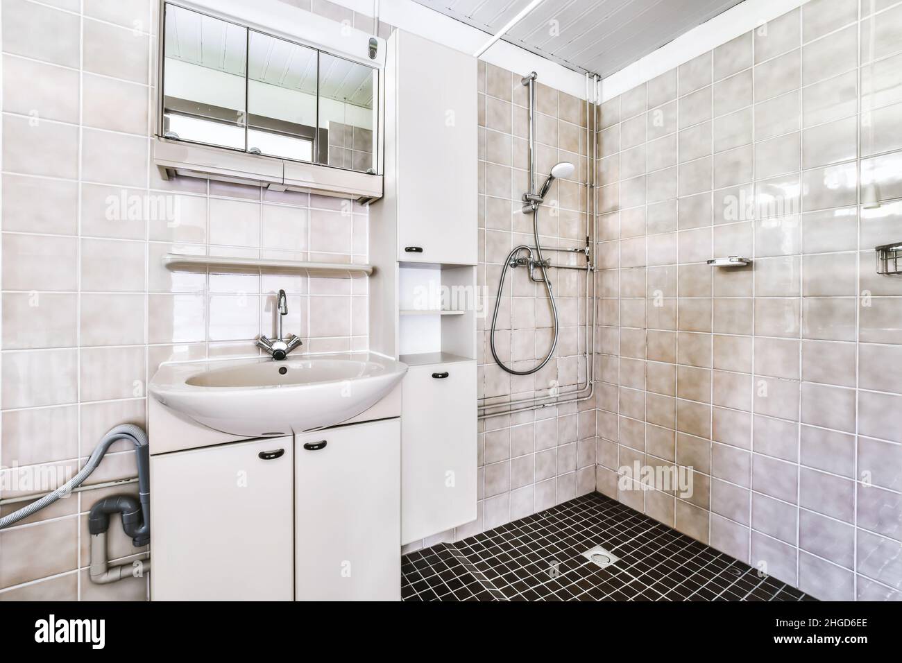 Beautiful bath area with black tiled floor and beige walls Stock Photo ...